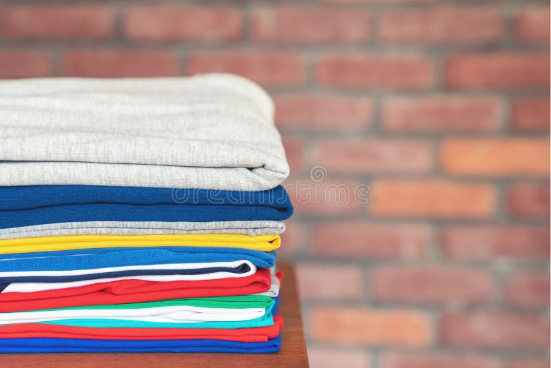 Stack of Folded Clothes on Table Indoor.Fresh Folded Cotton Clothing ...