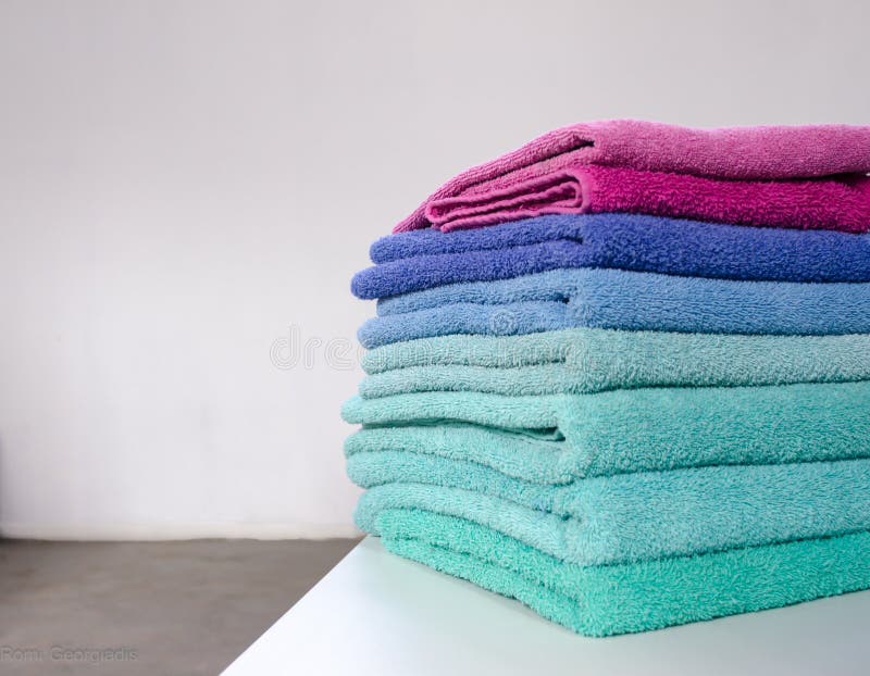Stack of Folded Colorful Towels on a White Table Stock Photo - Image of ...