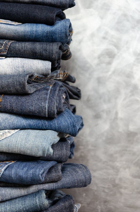 A Stack of Folded Jeans on Gray Background. Close-up of Jeans in ...