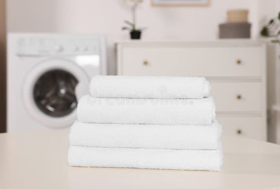 Stack of Folded Towels on White Table in Laundry Room Stock Image ...