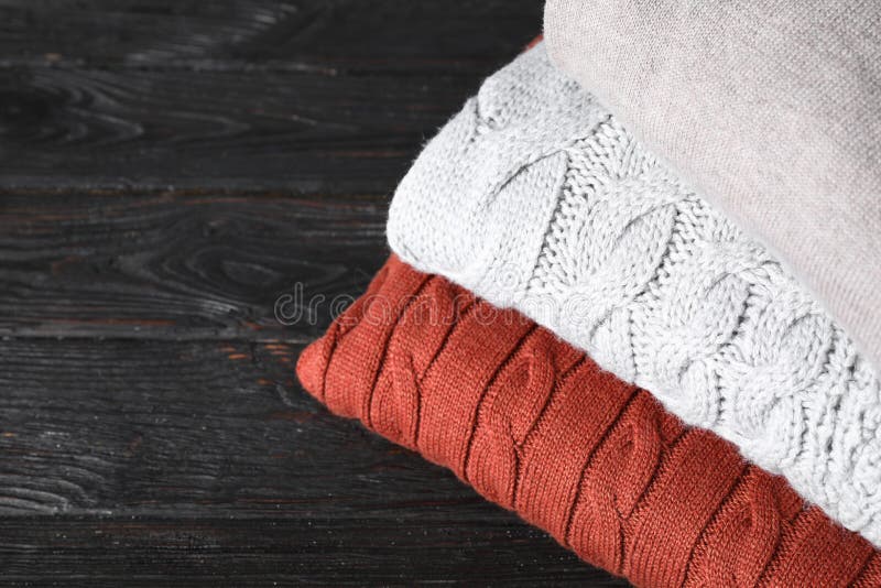 Stack of Folded Warm Sweaters on Black Wooden Table Stock Image - Image ...
