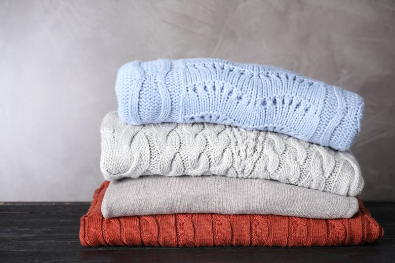 Stack of Folded Warm Sweaters on Black Table Stock Image - Image of ...