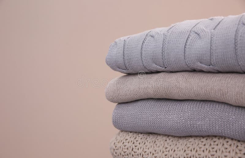 Stack of Folded Warm Sweaters on Grey Background, Closeup. Space for ...