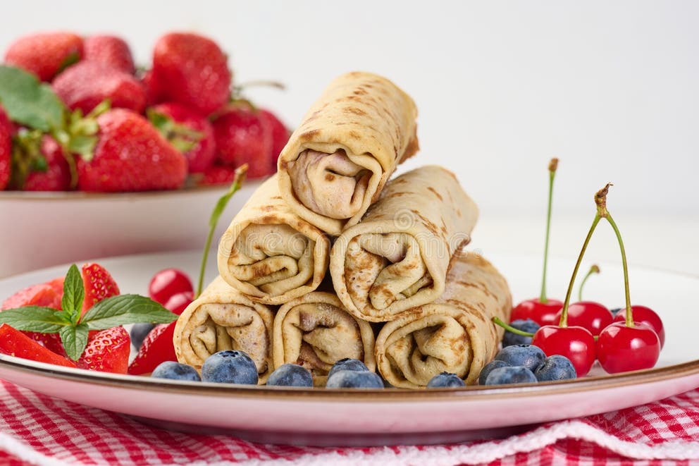 Stack of Fried Crepes with Filling on a Round Plate, White Table Stock ...