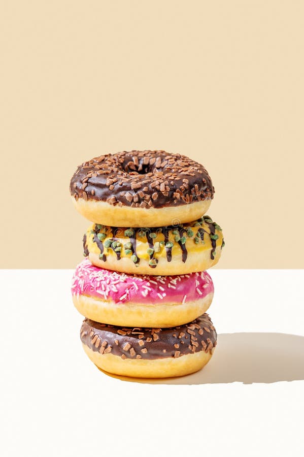 Stack of Glazed Donuts with Different Toppings on Beige and White ...