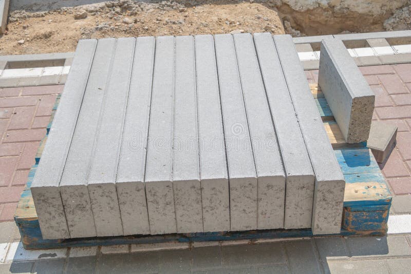 A Stack of Gray Pavers on Pallets, Concrete Pavers with Blue Edges ...