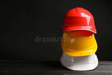 Stack of Hard Hats and Space for Text on Black Background. Stock Photo ...