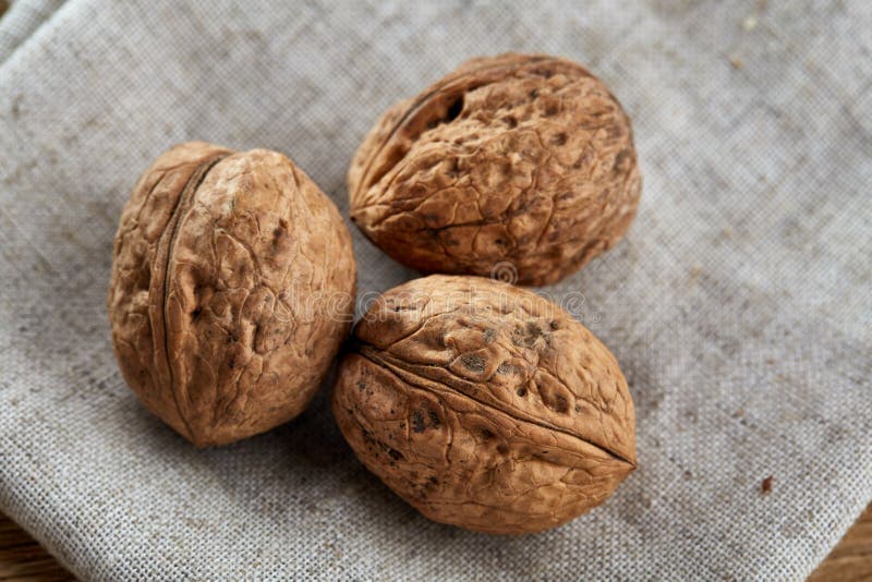 A Stack of Walnuts Piled Together and on Rustic Wooden Background ...