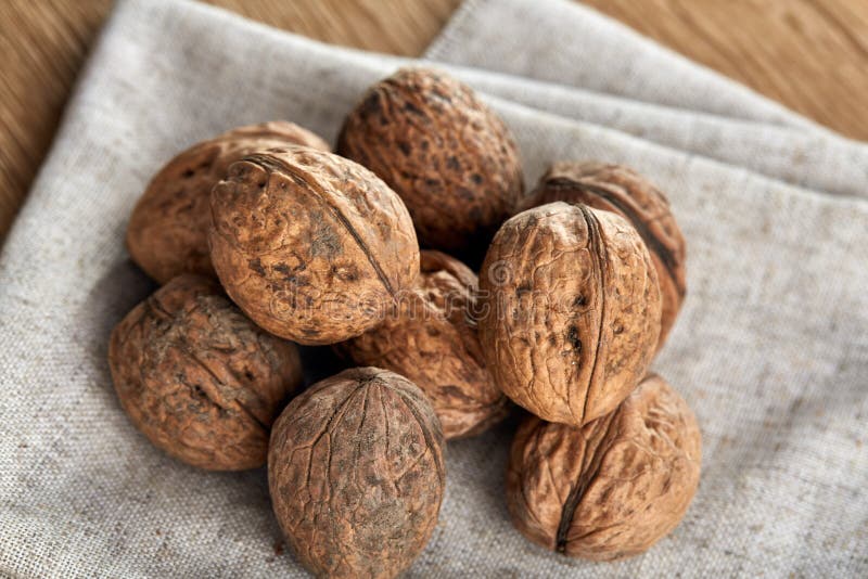 A Stack of Walnuts Piled Together and on Rustic Wooden Background ...