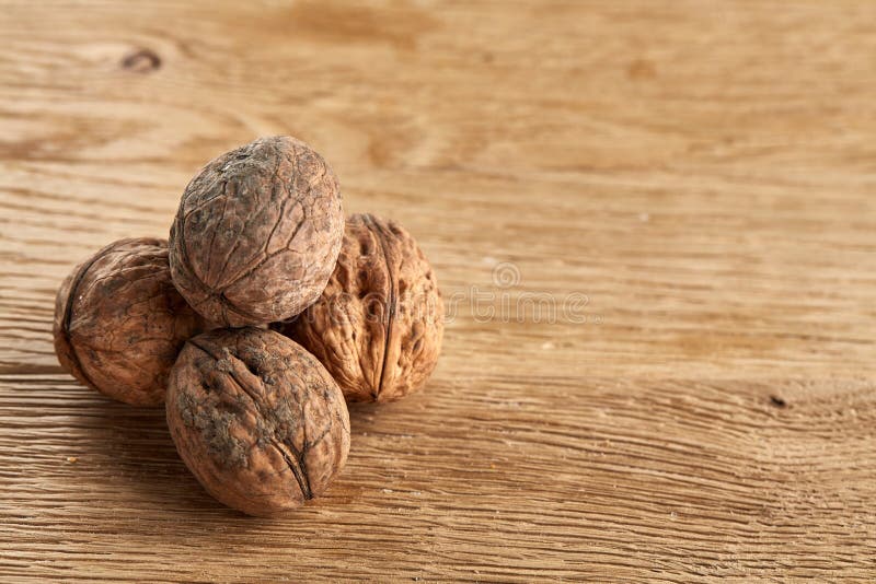 A Stack of Walnuts Piled Together and on Rustic Wooden Background ...