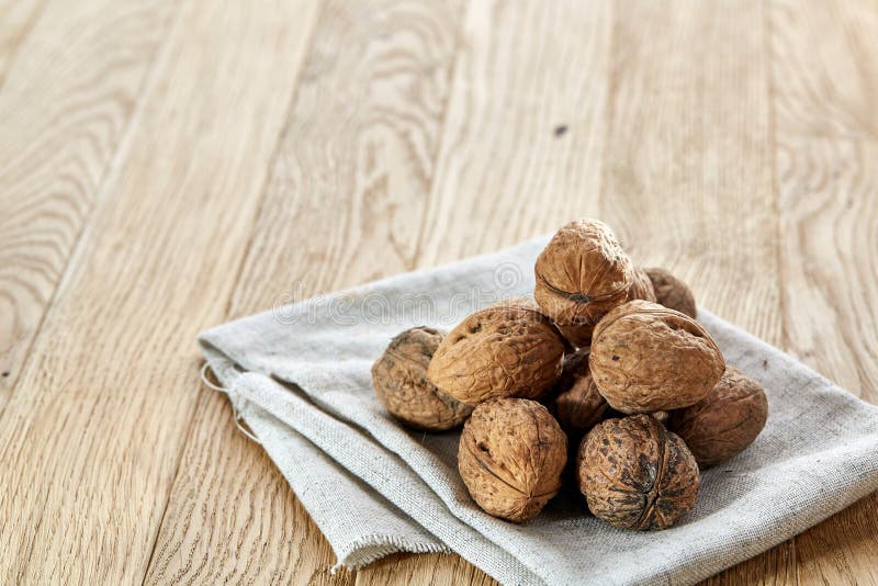 A Stack of Walnuts Piled Together and on Rustic Wooden Background ...