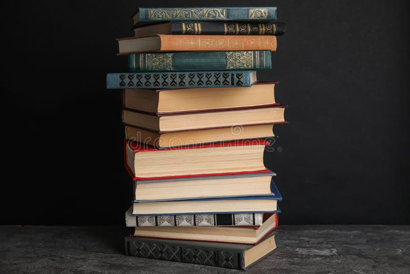 Stack of Hardcover Books on Stone Table Against Black Background Stock ...