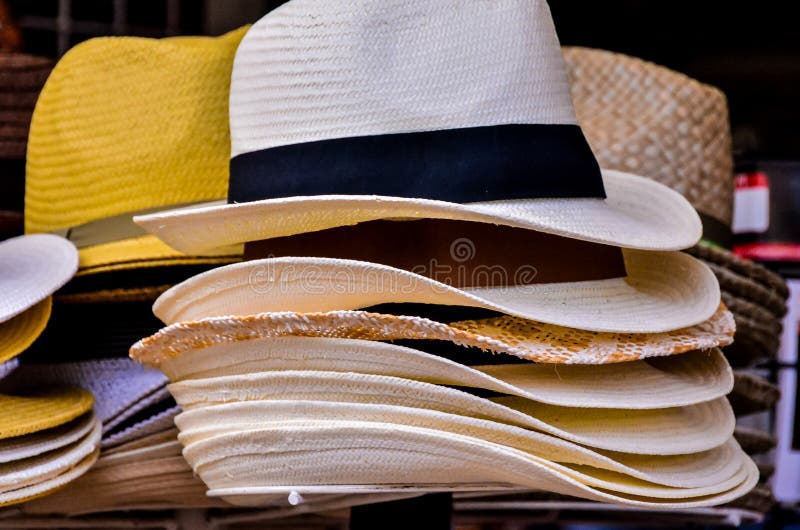 A Stack of Hats, Including a Straw Hat, a White Hat, and a Yellow Hat ...