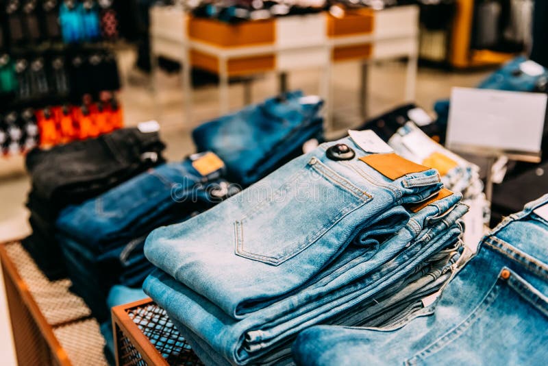 Stack of Jeans on Shelves in Store of Shopping Center Stock Photo ...
