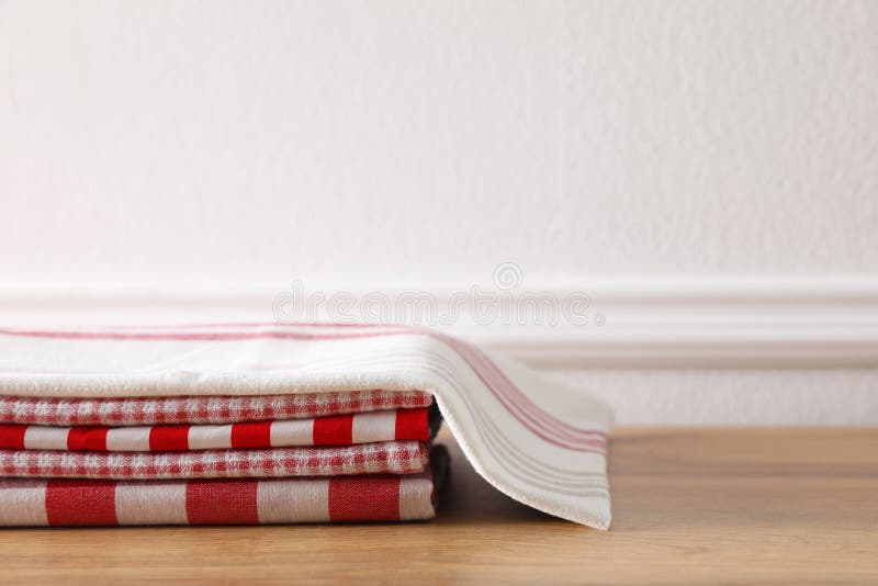 Stack of Kitchen Towels on Wooden Table Near White Wall. Space for Text ...