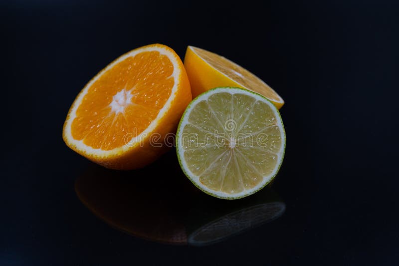 Stack of Lime, Orange and Lemon Halves on a Isolated Black Background ...