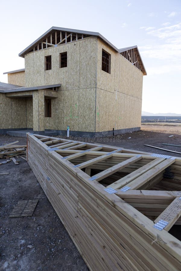 Stack of Lumber Pieces Next To an almost Finished Home in a New ...