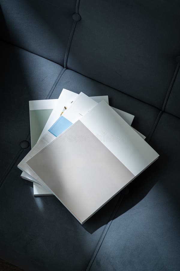 Stack of Magazines on a Black Leather Couch in Soft Light Stock Photo ...