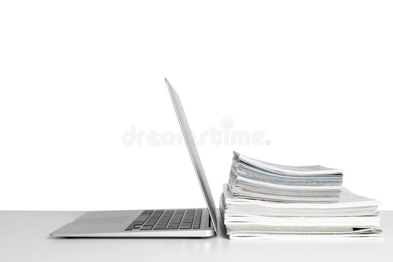 Stack of Magazines and Laptop on Table Near White Wall Stock Photo ...