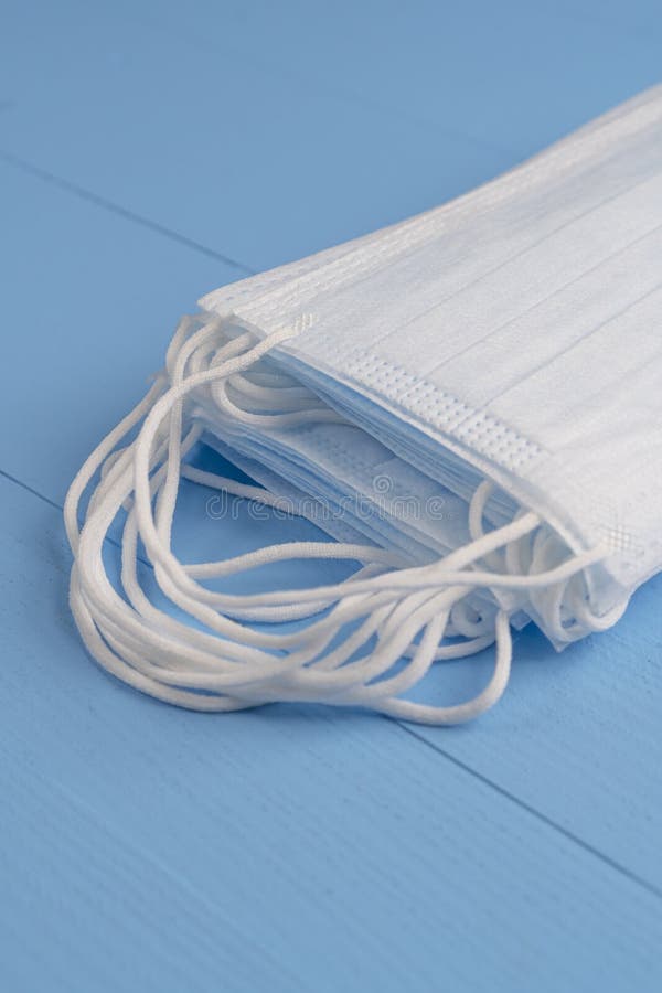 Stack of Medical Protective Masks on a Light Blue Wooden Texture ...