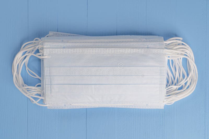 Stack of Medical Protective Masks on a Light Blue Wooden Texture ...