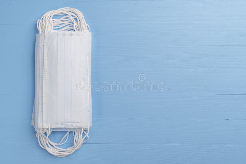 Stack of Medical Protective Masks on a Light Blue Wooden Texture ...