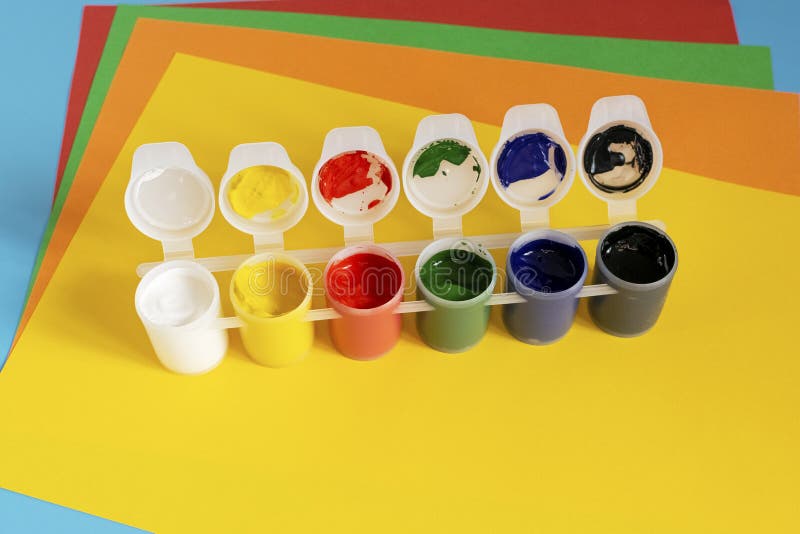 Stack of Multi-colored Paper and Paint for Drawing on a Blue Background ...