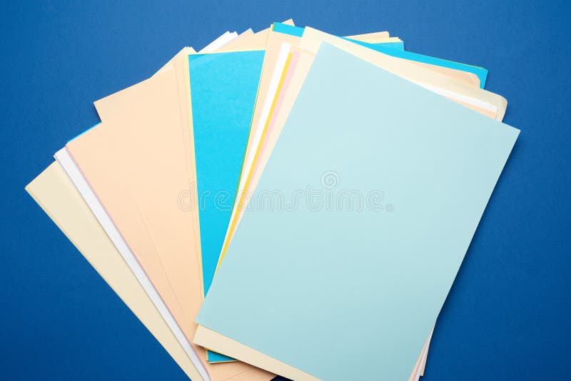 Stack of Multi-colored Paper Colored Sheets on a Blue Background Stock ...