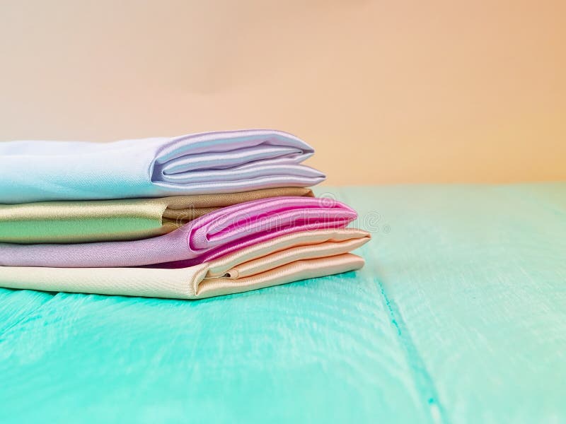 A Stack of Multi-colored Satin Fabric on a Blue Background, Space for ...