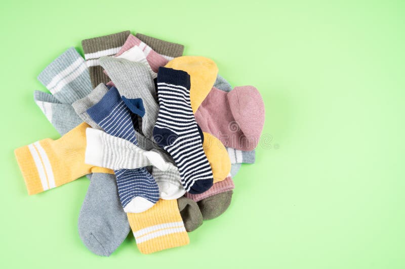 Stack of Multi Colored Socks on Pastel Green Background. Consumer ...