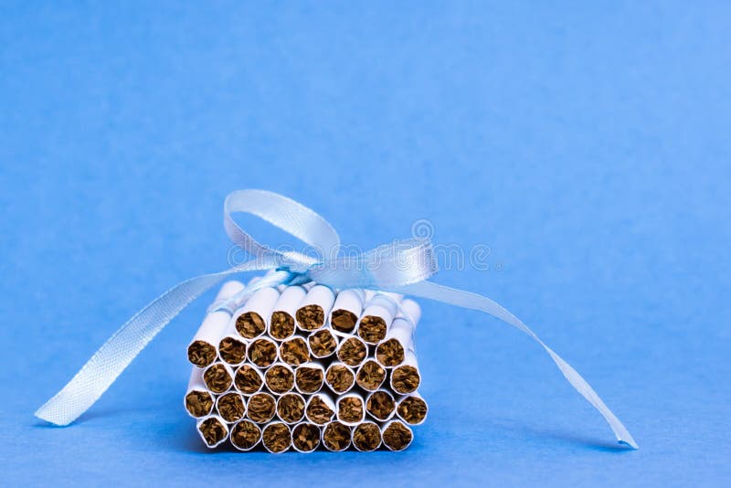 A Stack of New Thin Cigarettes is Tied with a Blue Ribbon with a Bow ...