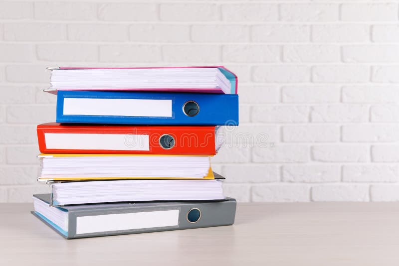 Stack of Office Folders on Wooden Table Near White Brick Wall, Space ...