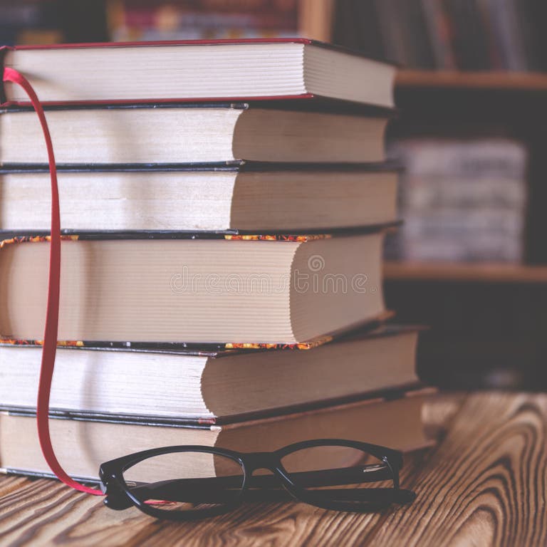 A Stack of Old Books and Black Glasses on a Wooden Table Stock Image ...