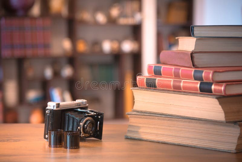 Stack of Old Books and Old Camera Over Wooden Table, Retro Filtered ...