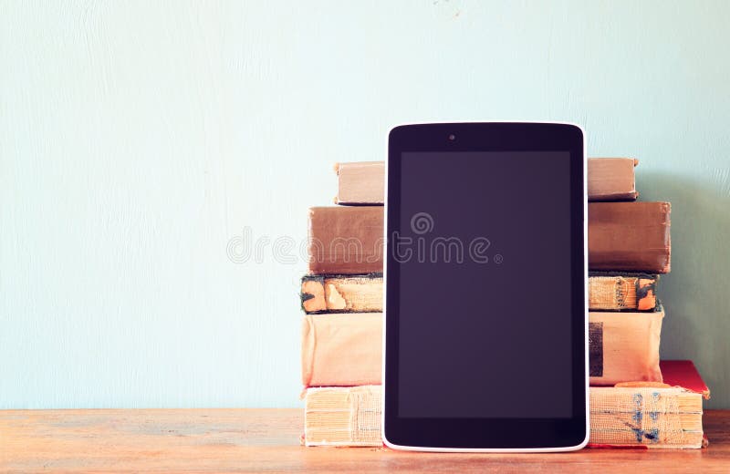 Stack of Old Books and Tablet Over Wooden Shelf. New Technology Concept ...