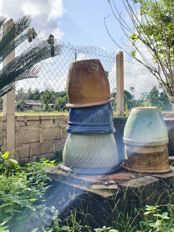 A Stack of Old Ceramic Pots Sits on a Concrete Surface, Surrounded by ...