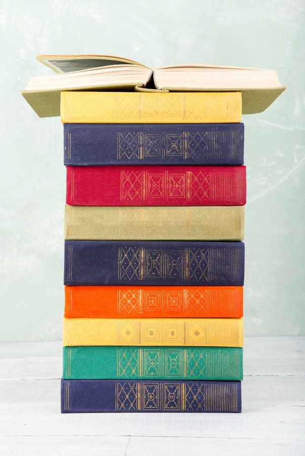 Stack of Color Books, Eyeglasses, Stationery and Magnifying Glass on a ...