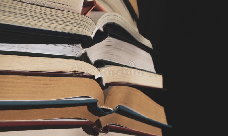 A Stack of Open Books in the Dark. the Open Books are Stacked on Top of ...