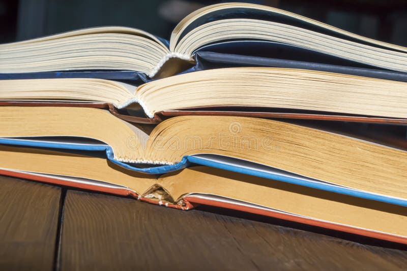 A Stack of Open Books on a Wooden Table. Side View of the Books. on the ...