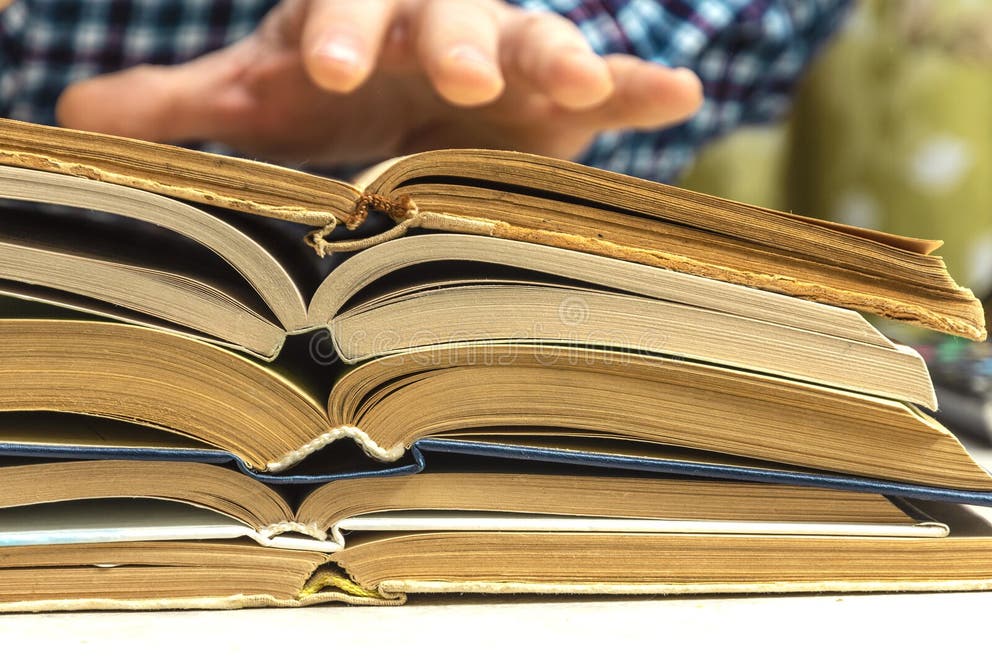 A Stack of Open Old Books and a Hand Over Them. Stock Image - Image of ...
