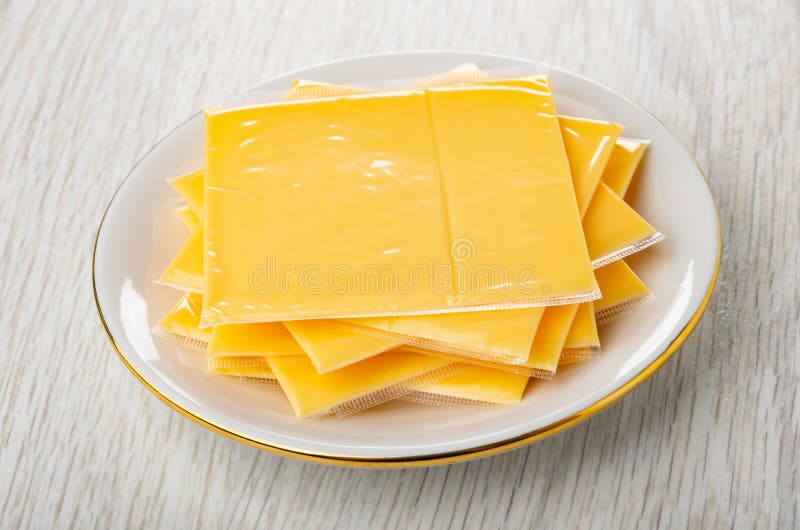 Stack of Packages of Cheese in Saucer on Wooden Table Stock Photo ...