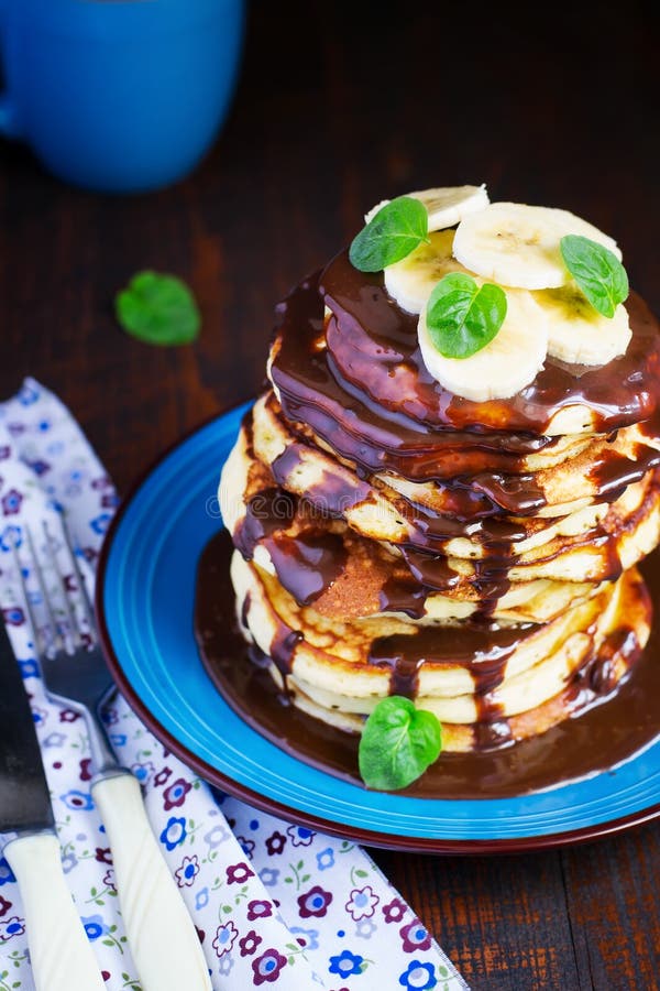 Stack of Pancakes with Chocolate Topping and Banana on a Blue Pl Stock ...