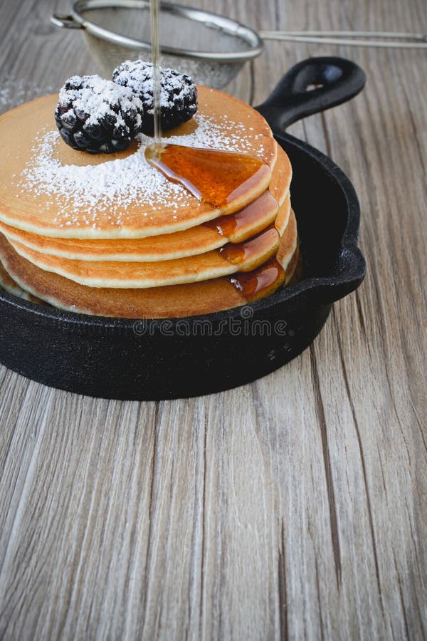 Stack of Pancakes in Frying Pan with Blackberries and Maple Syrup Stock ...