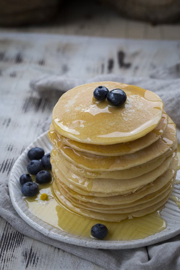 Stack of Pancakes with Honey and Blueberry at White Plate on White Wood ...