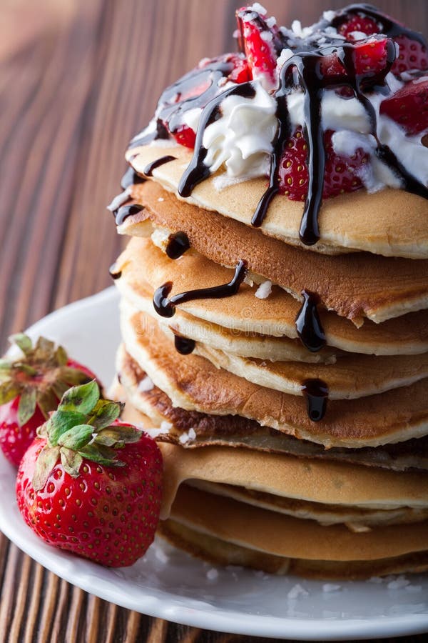 Stack Of Pancakes With Strawberries, Whip Cream And Chocolate Syrup On ...