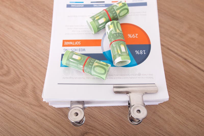 A Stack of Paper Business Documents and Several Rolls of Euro Banknotes ...
