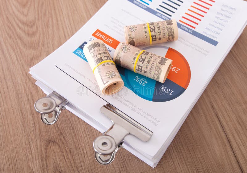 A Stack of Paper Business Documents and Several Rolls of Yen Bills on ...
