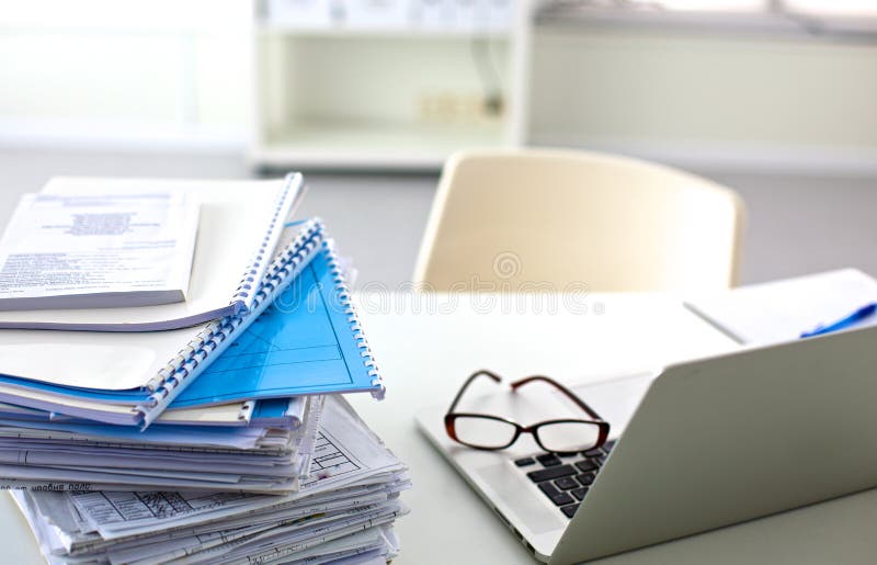 A Stack of Papers on the Desk with a Computer Stock Image - Image of ...
