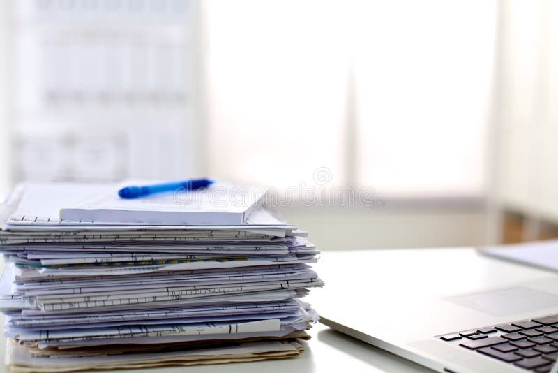 A Stack of Papers on the Desk with a Computer Stock Image - Image of ...