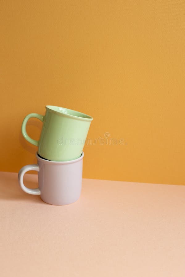 Stack of Pastel Color Mug Cup on Pink Table. Orange Wall Background ...